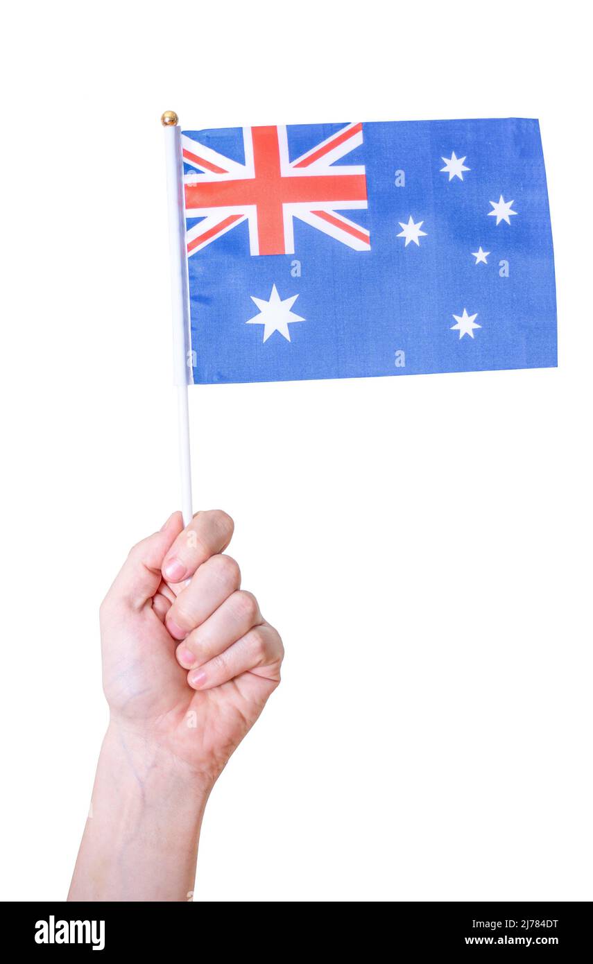 A hand holds the flag of Australia against a white isolated background ...