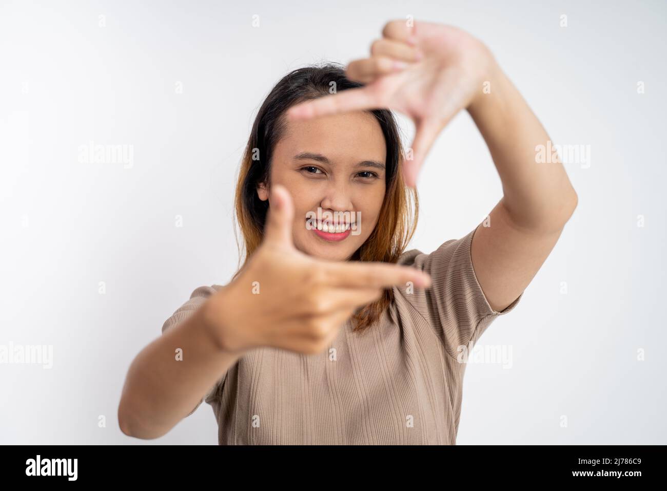 woman looking at the camera from between fingers forming a frame Stock ...