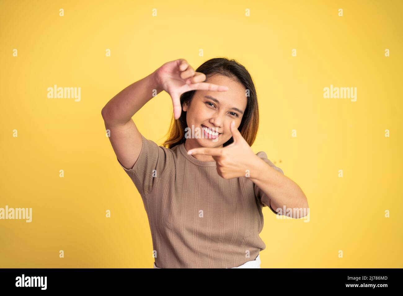 woman looking at the camera from between fingers forming a frame Stock ...