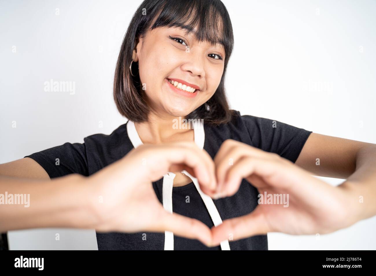 woman smiling in heart shape with fingers on isolated Stock Photo - Alamy