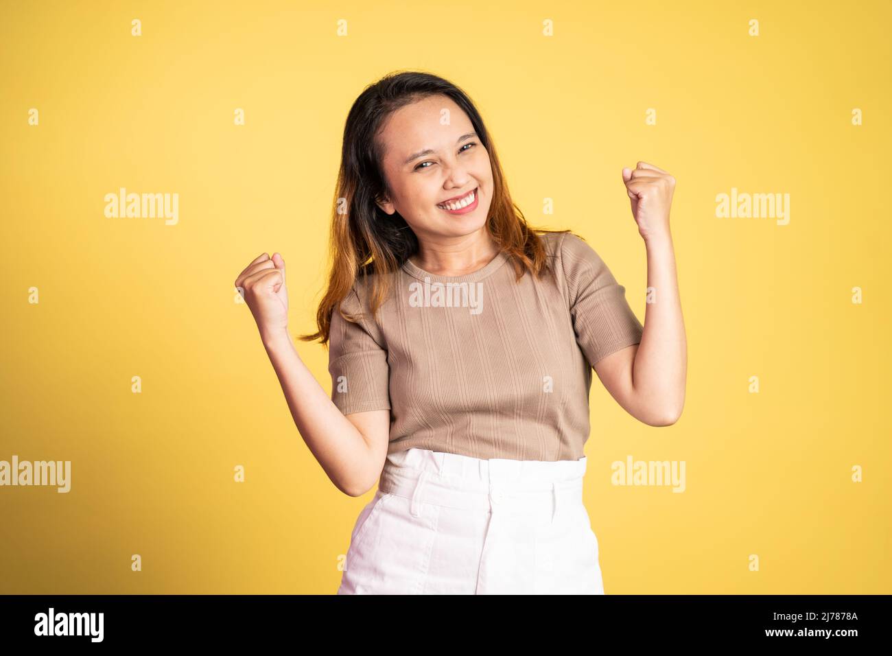 asian woman clenching hands while celebrating success Stock Photo - Alamy