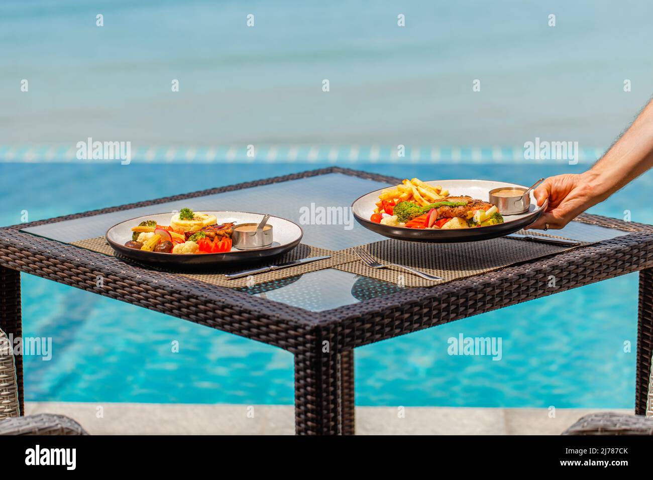 Male waiter hand serving lunch in restaurant at hotel, summer vacations ...