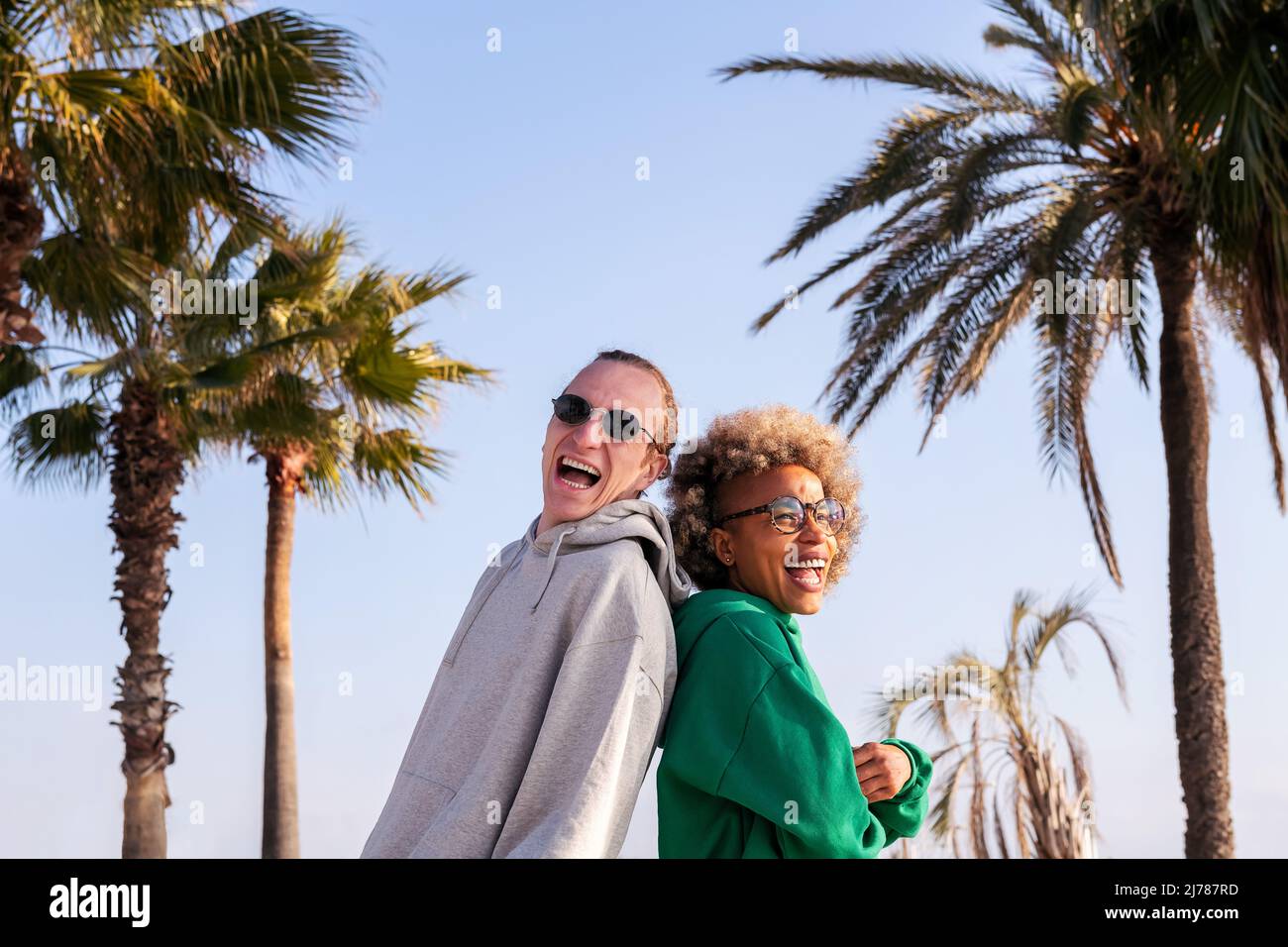 young couple laughing funny leaning back to back Stock Photo - Alamy