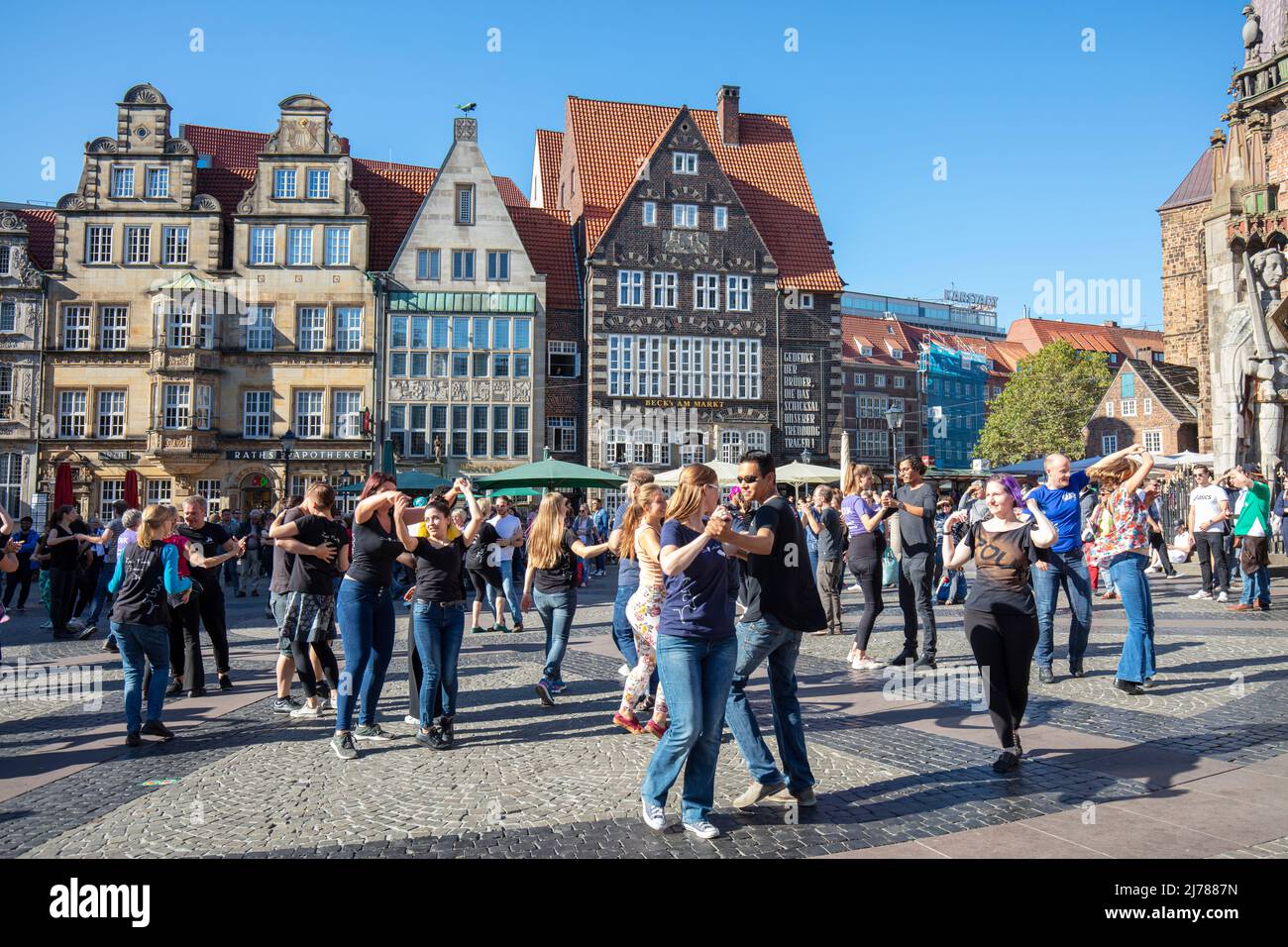 Groups of people dancing in front of historic buildings in the UNESCO ...