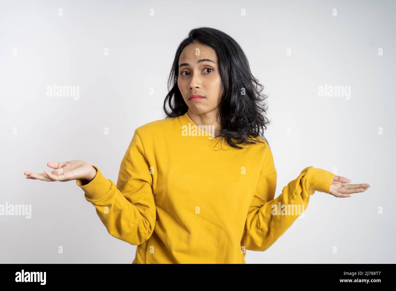 asian woman opening two palms on isolated background feeling uncertain ...