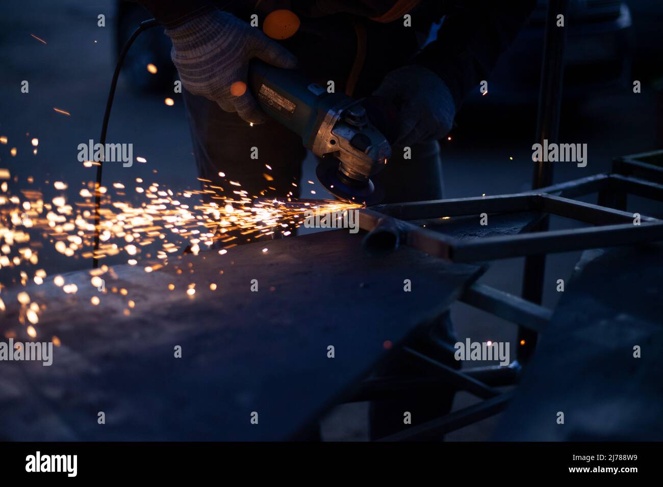 Sparks from grinding metal. Steel processing in workshop. Lights in ...