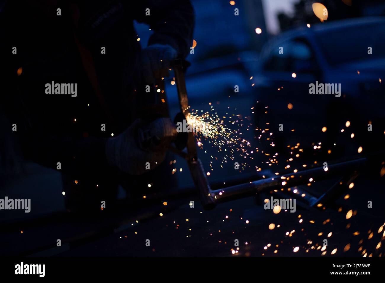 Sparks from grinding metal. Steel processing in workshop. Lights in ...