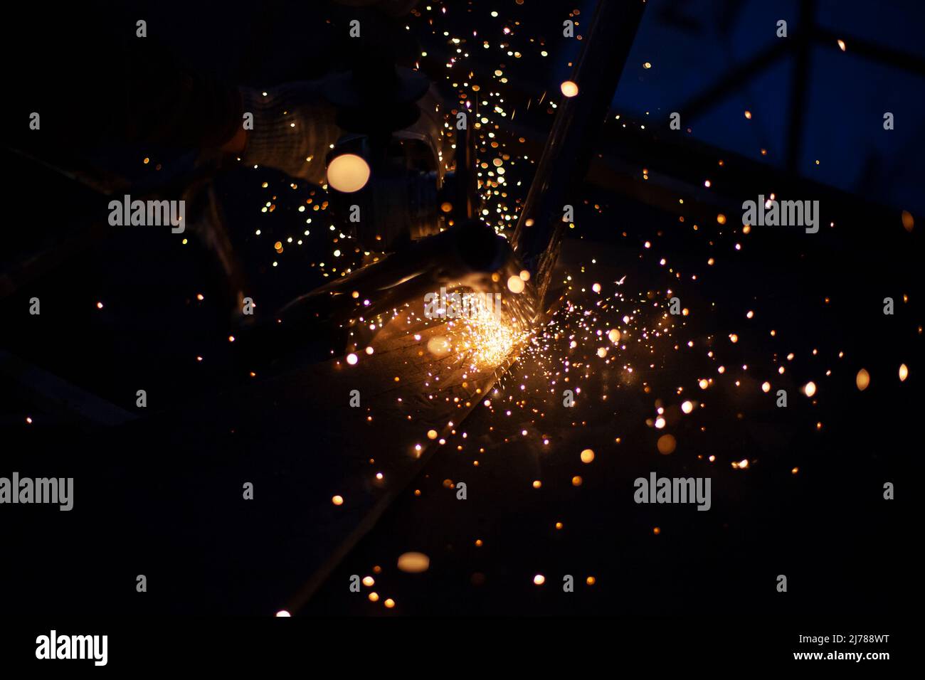Sparks from grinding metal. Steel processing in workshop. Lights in ...