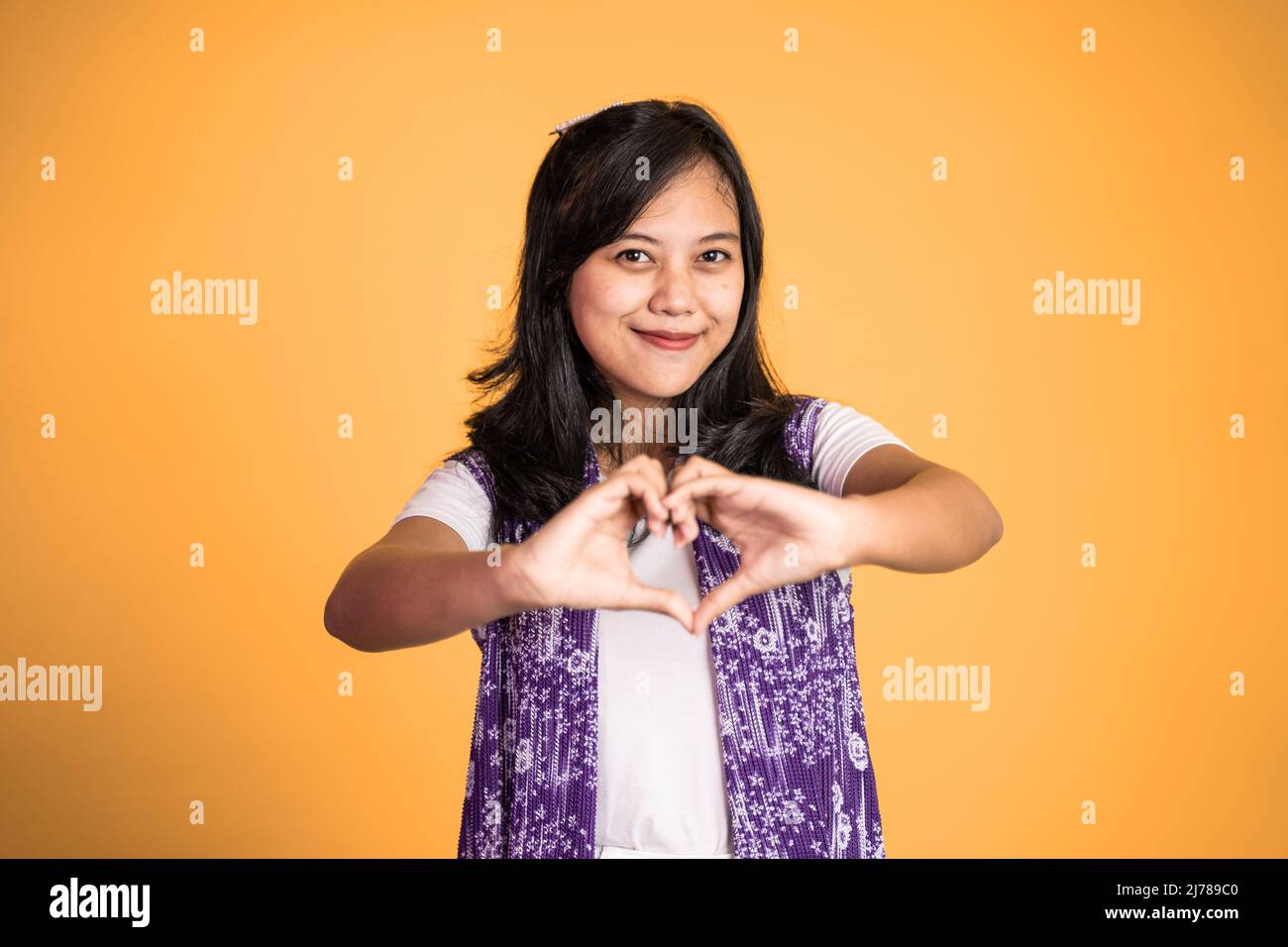 woman smiling in heart shape with fingers on isolated Stock Photo - Alamy
