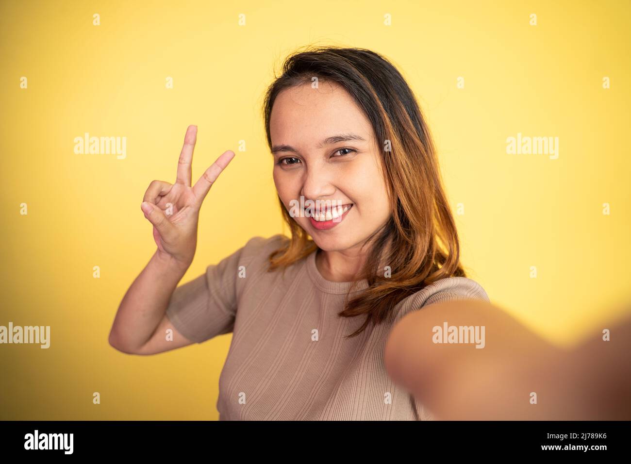 woman with peaceful hand gesture on isolated background Stock Photo - Alamy