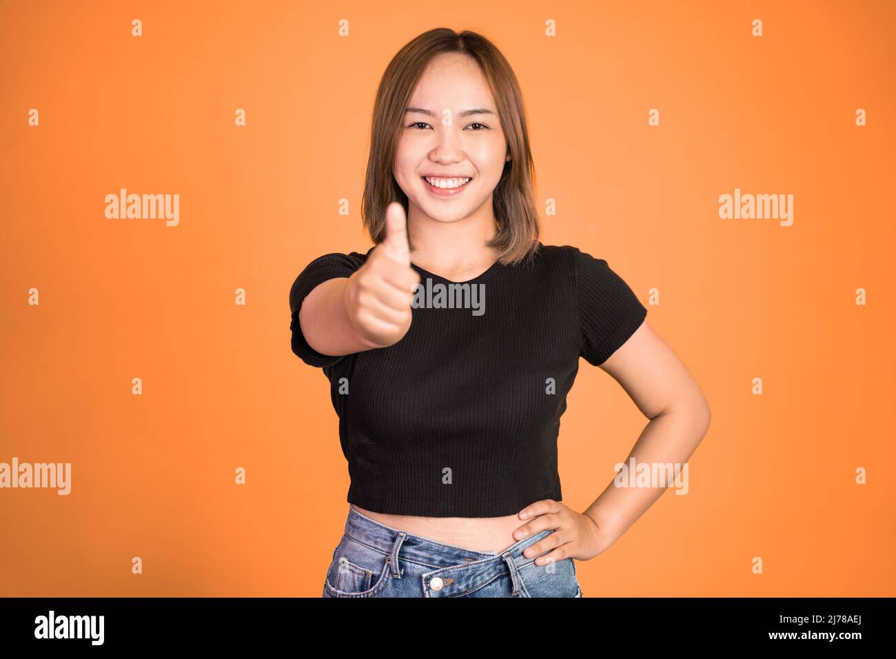 woman stand with thumbs up on isolated background Stock Photo - Alamy