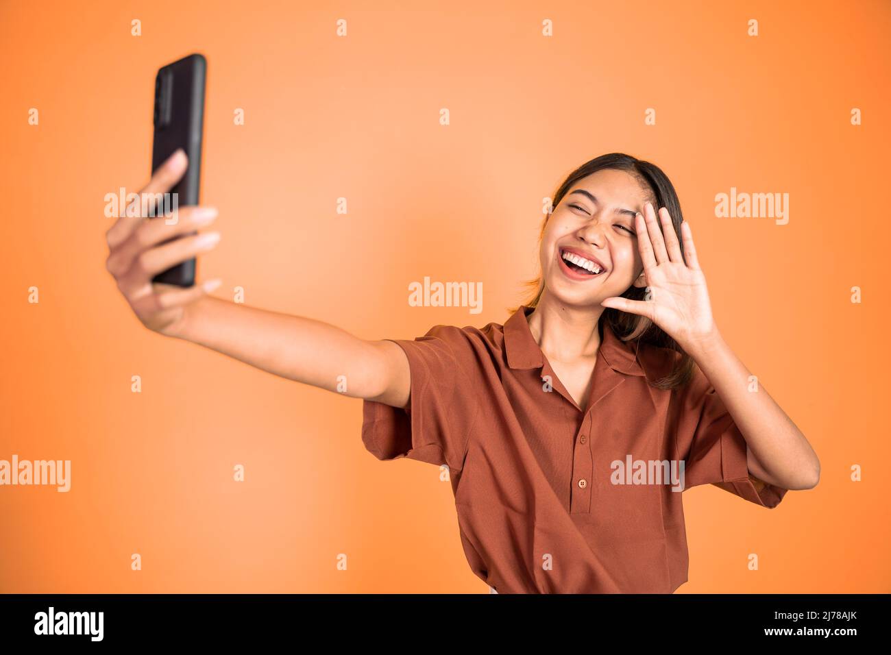 woman make a video call using mobile phone with saying hello gesture ...