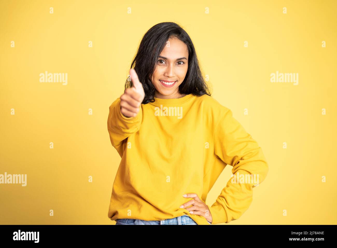 woman stand with thumbs up on isolated background Stock Photo - Alamy