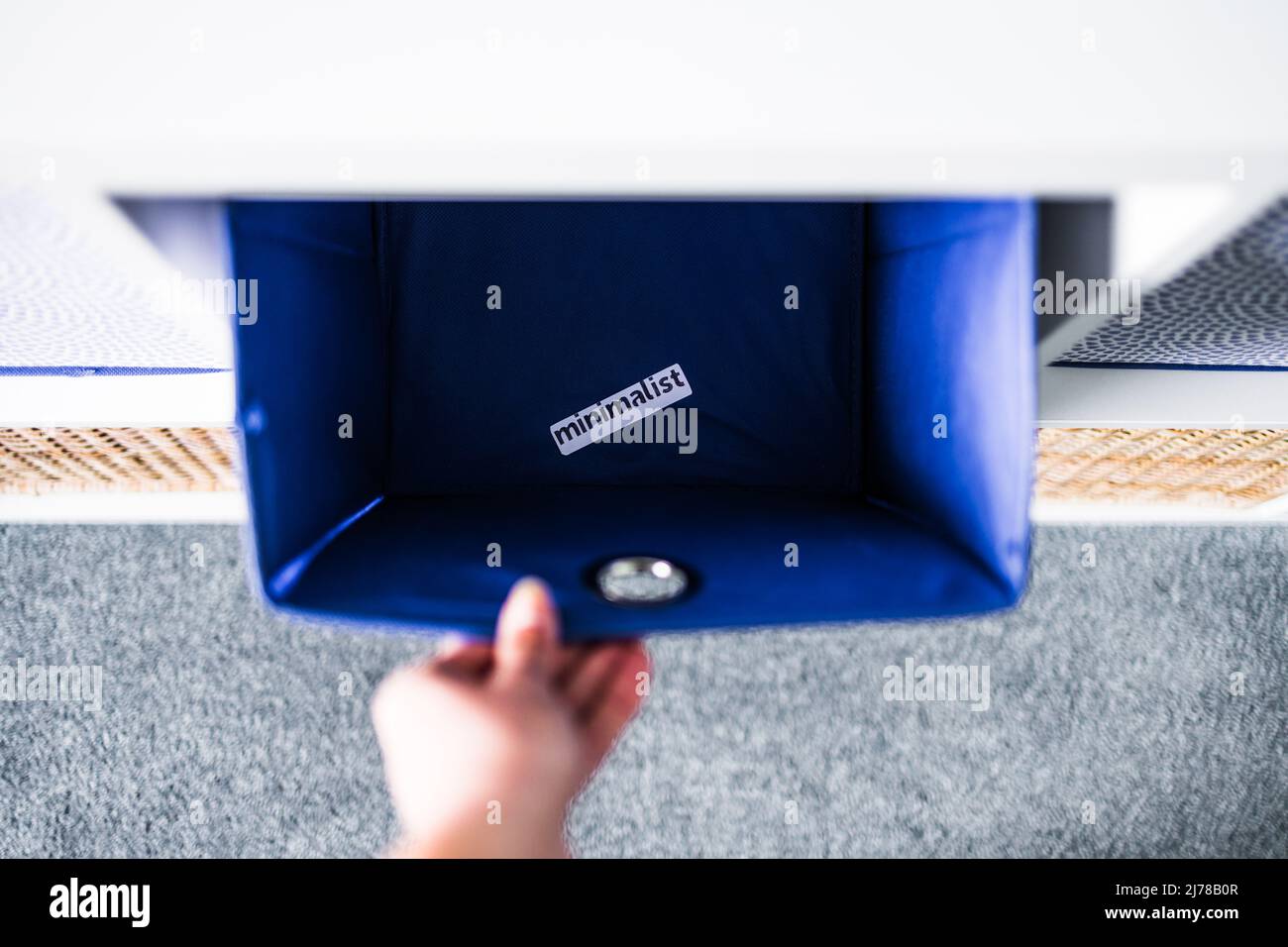 hand grabbing storage cube with Minimalism label inside of it with ...