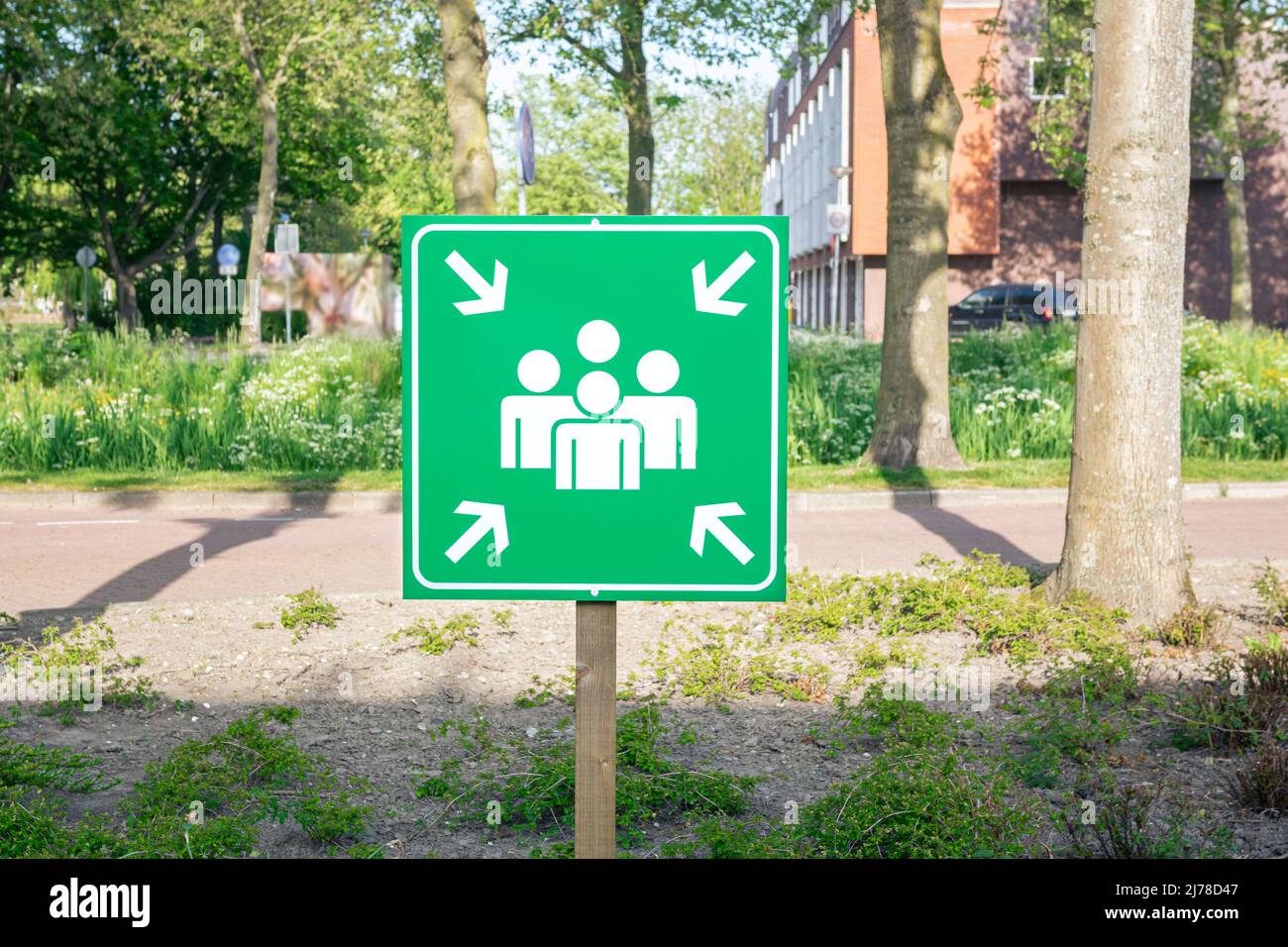 Green assembly point sign. Sign with a symbol that shows where people ...