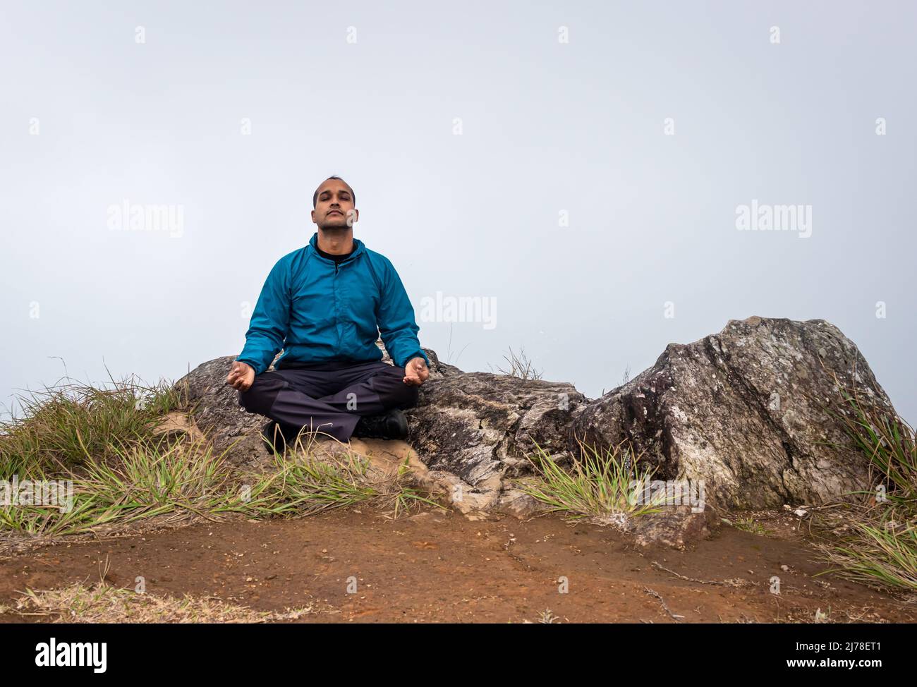 man meditating at mountain rock with white mist background from flat ...