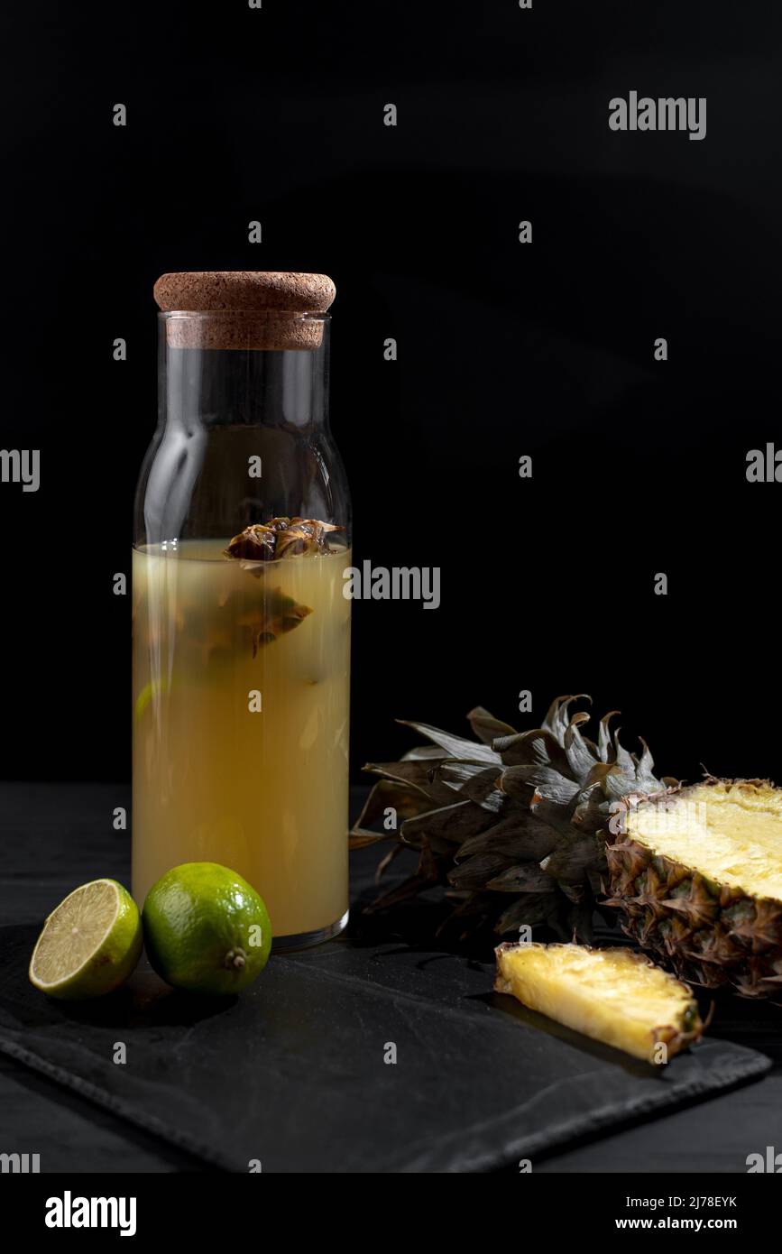 Fermented pineapple lemonade on a black background. Vertical frame ...