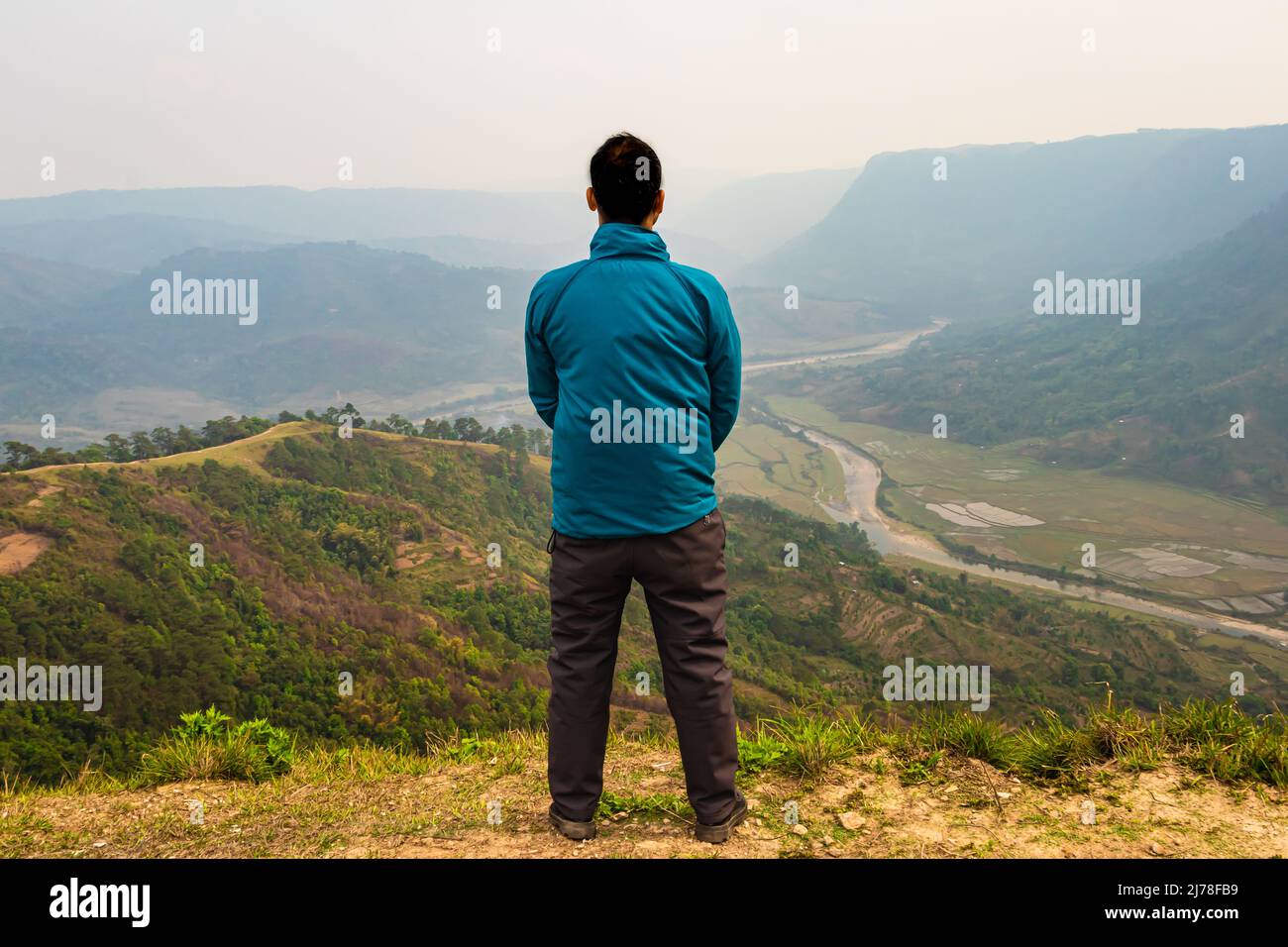 man standing alone at hill top with misty mountain rage background from ...