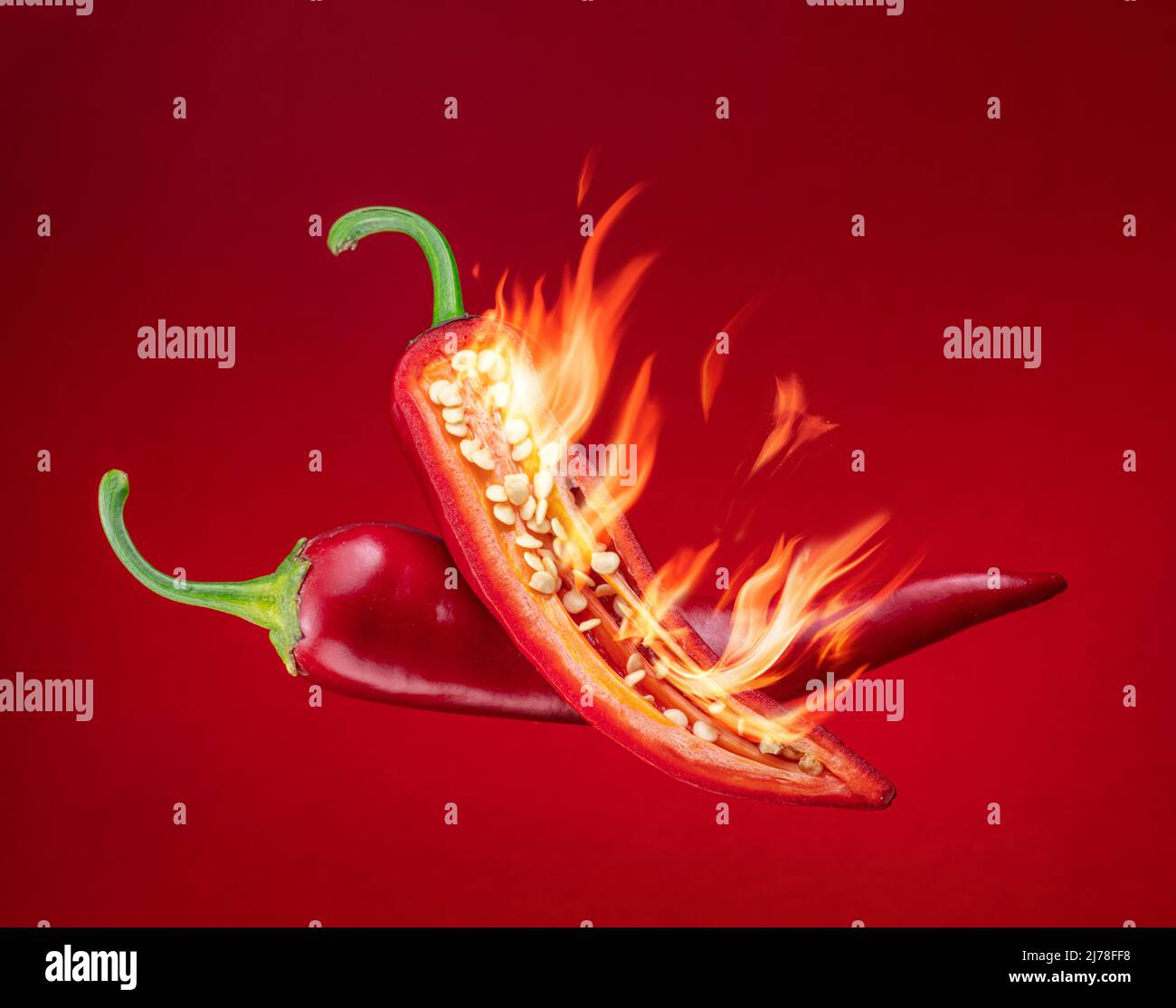 Fresh red chilli pepper in fire as a symbol of burning feeling of spicy ...