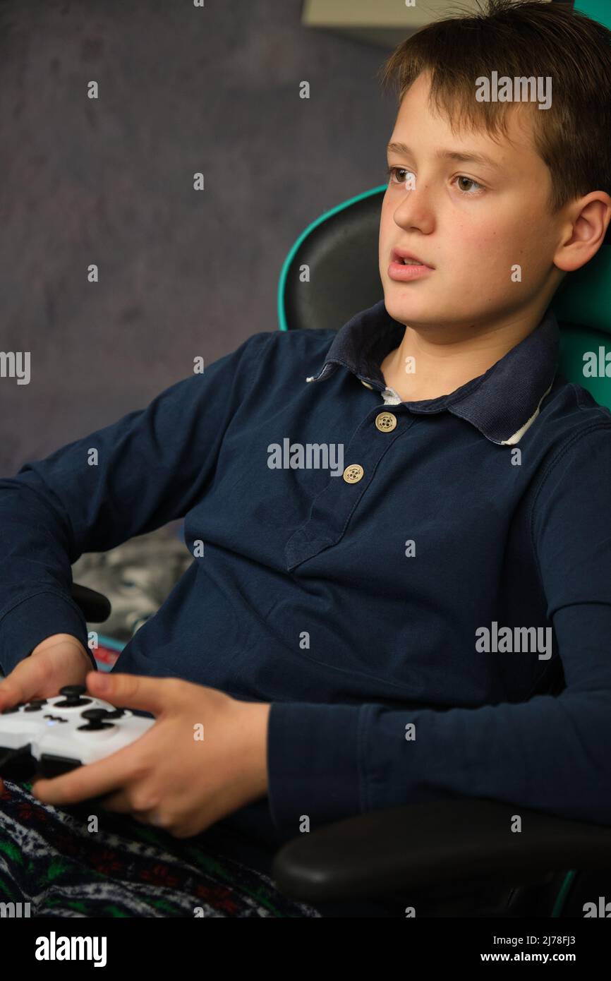 the boy is playing a video game console Stock Photo - Alamy
