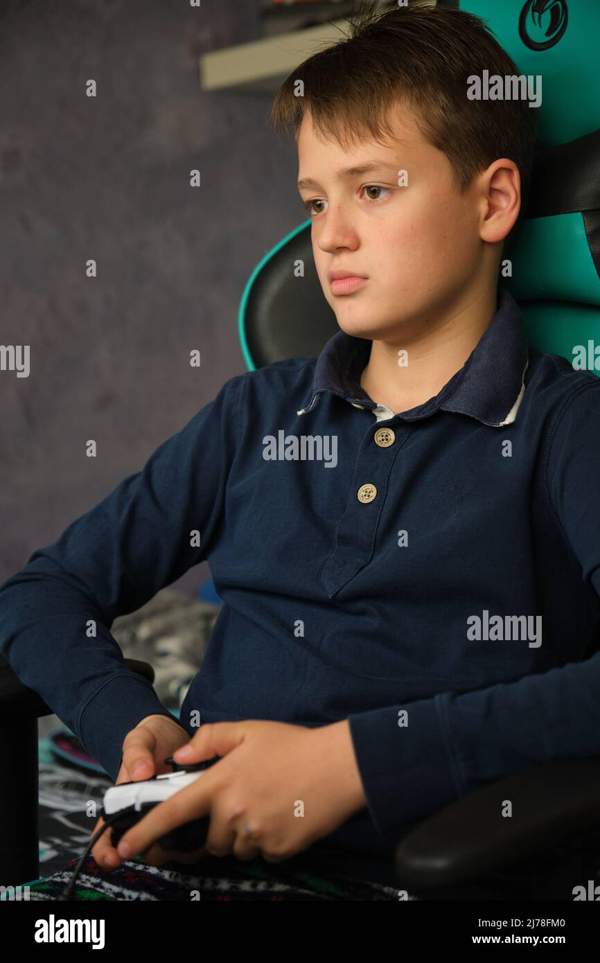 the boy is playing a video game console Stock Photo - Alamy