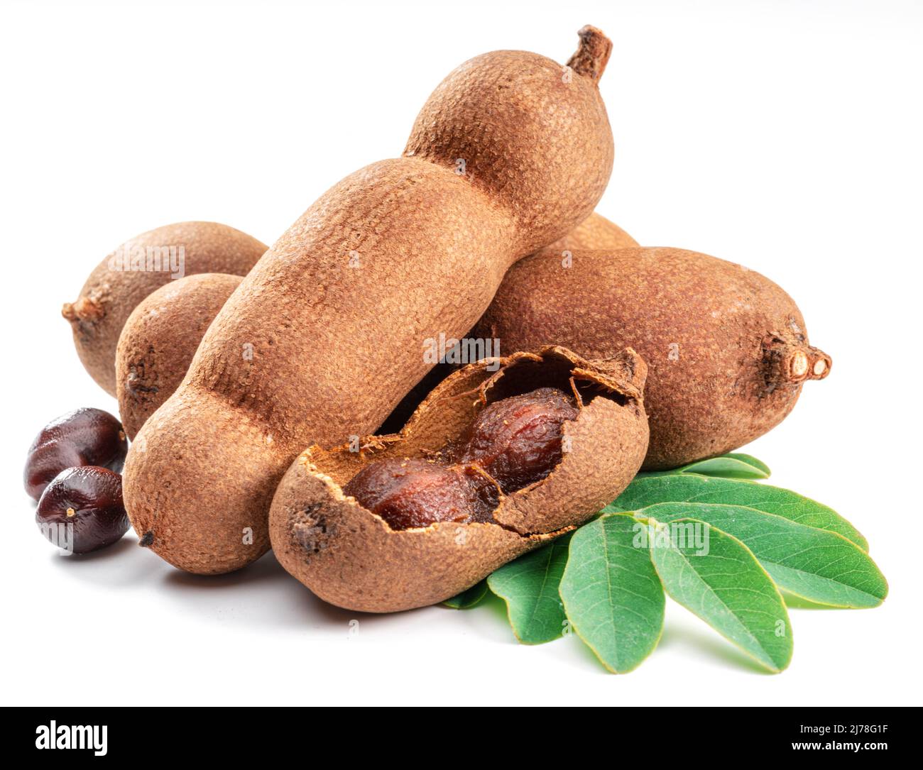 Ripe tamarind fruit, leaves and some tamarind seeds isolated on white ...