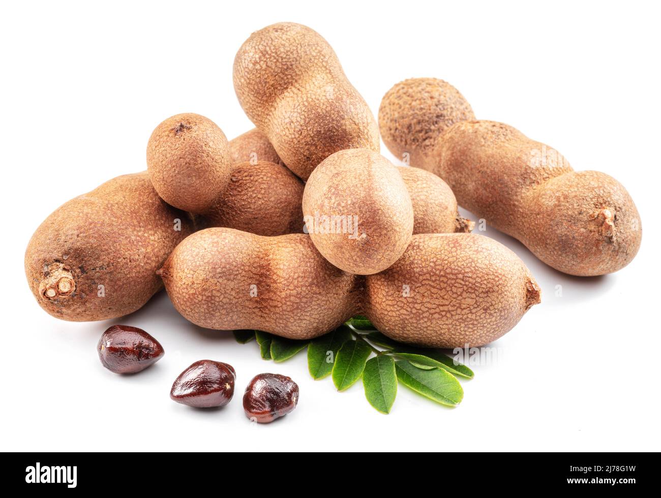 Ripe tamarind fruit, leaves and some tamarind seeds isolated on white ...