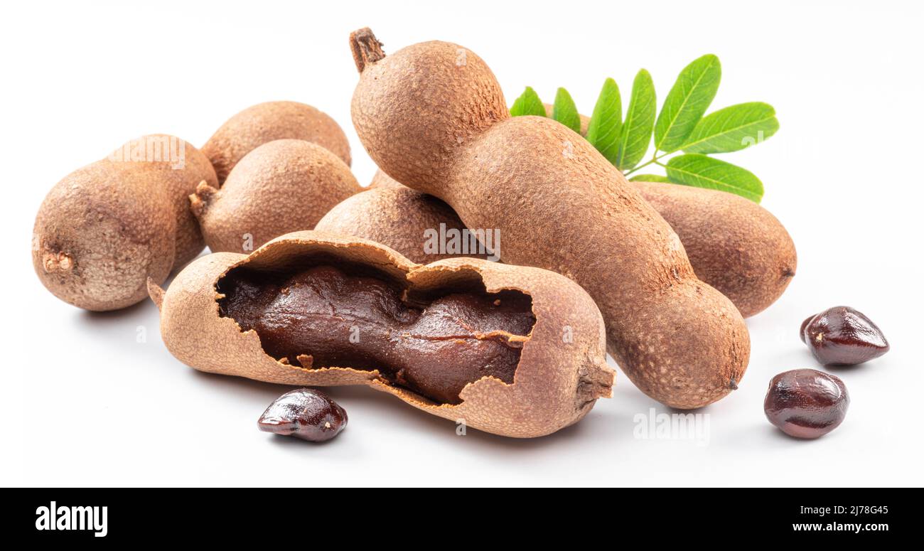 Ripe tamarind fruit, leaves and some tamarind seeds isolated on white ...