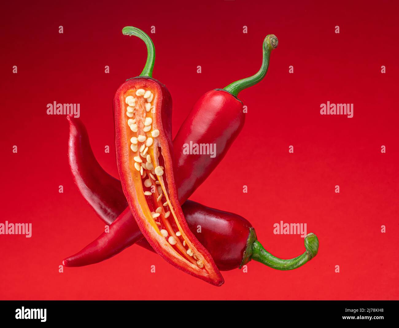 Fresh red chilli peppers and cross sections of chilli pepper with seeds ...
