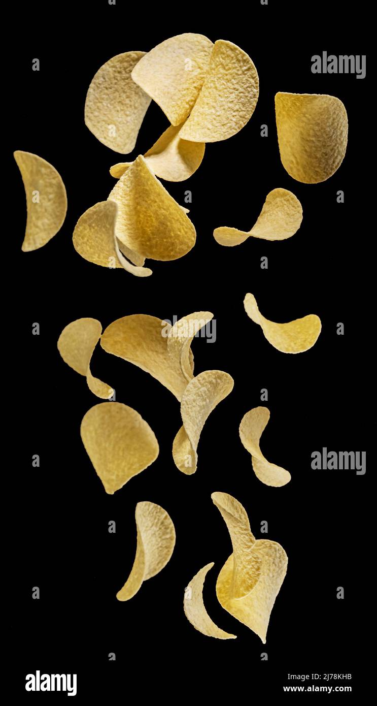 Delicious potato chips floating in the air. Black background. Fast food ...