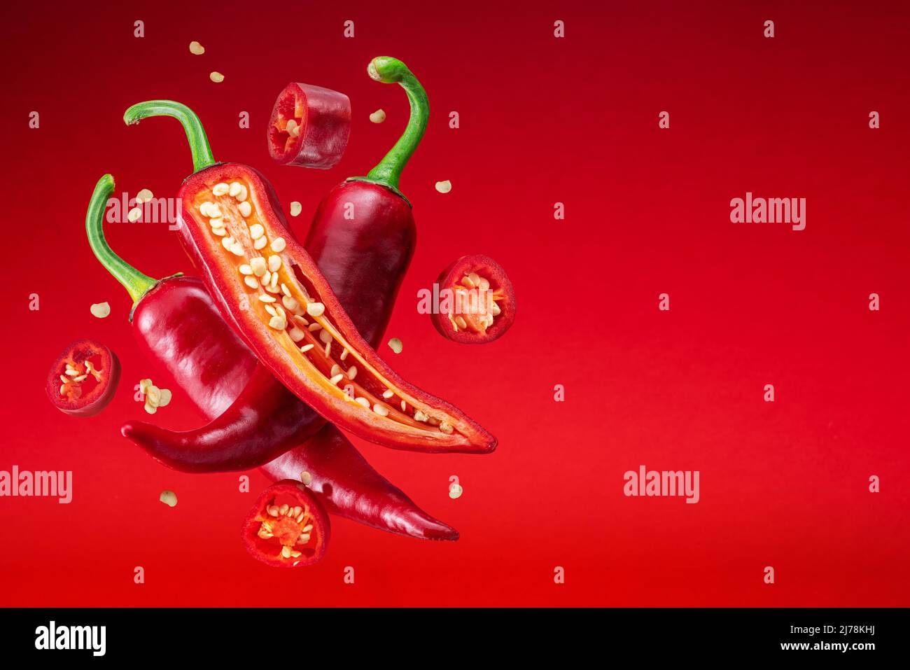 Fresh red chilli peppers and cross sections of chilli pepper with seeds ...