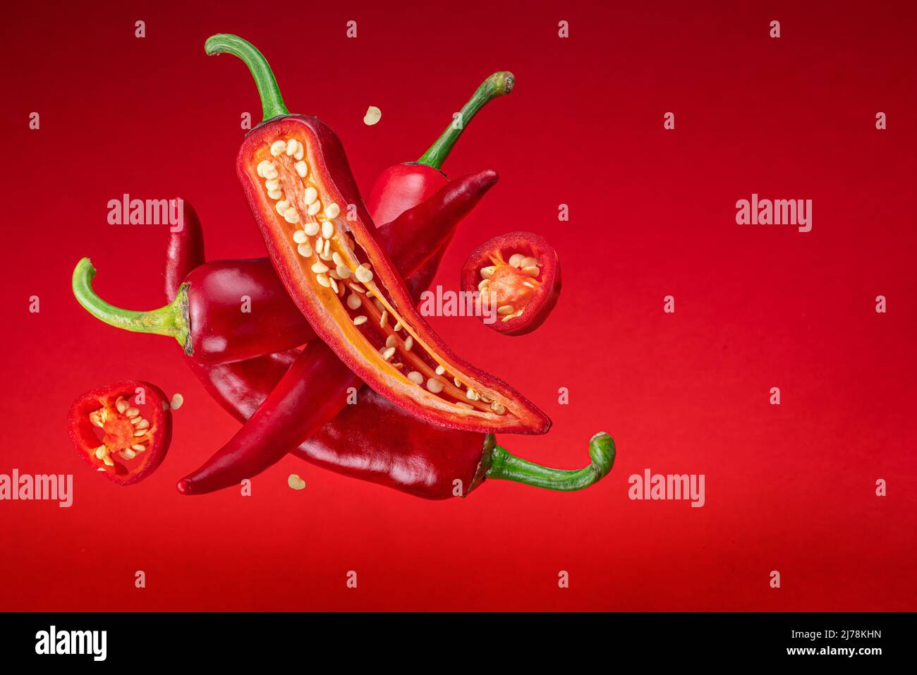 Fresh red chilli peppers and cross sections of chilli pepper with seeds ...
