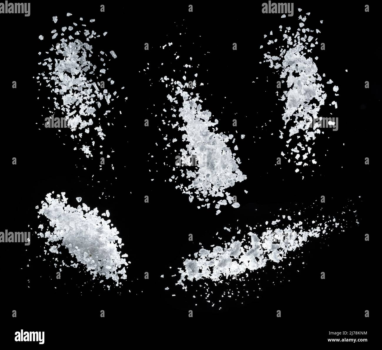 Edible salt crystals falling down at black background Stock Photo - Alamy