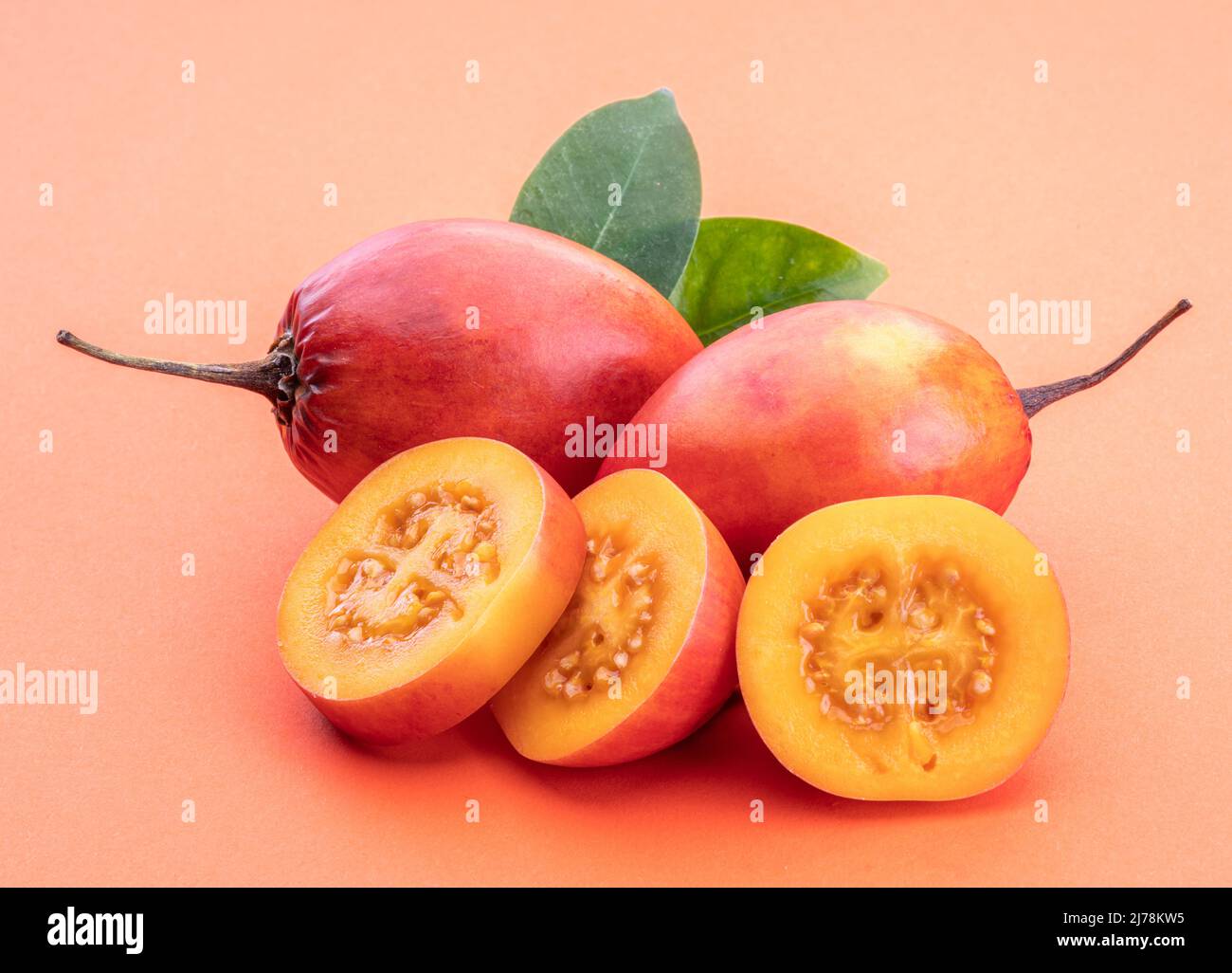 Ripe tamarillo fruits with slices and tamarillo leaves isolated on a ...