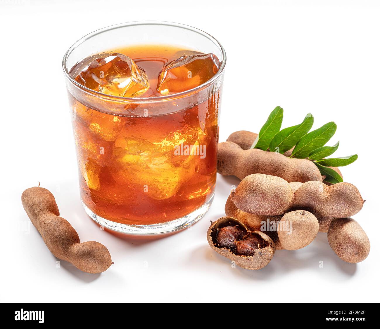Glass of cool refreshing tamarind drink and some tamarind fruit on ...