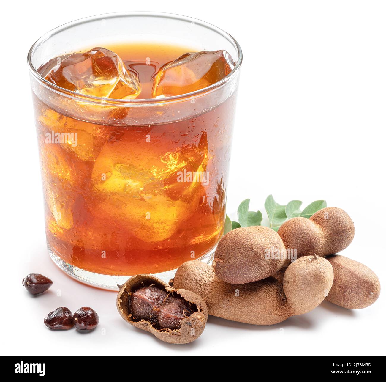 Glass of cool refreshing tamarind drink and some tamarind fruit on ...
