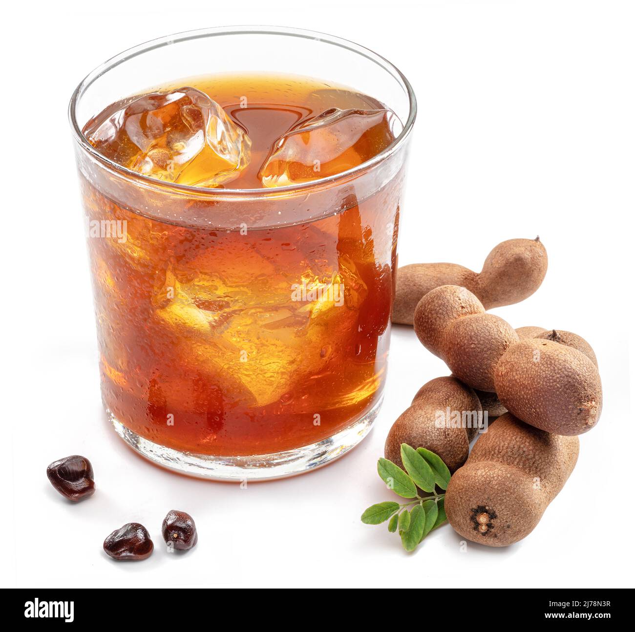 Glass of cool refreshing tamarind drink and some tamarind fruit on ...