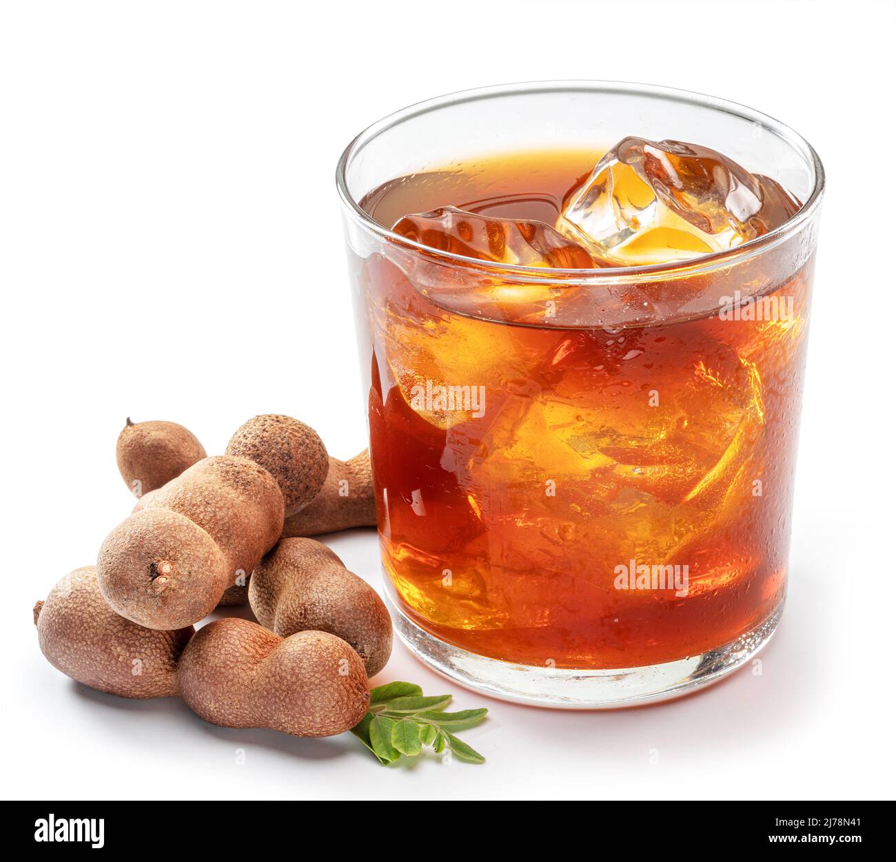 Glass of cool refreshing tamarind drink and some tamarind fruit on ...