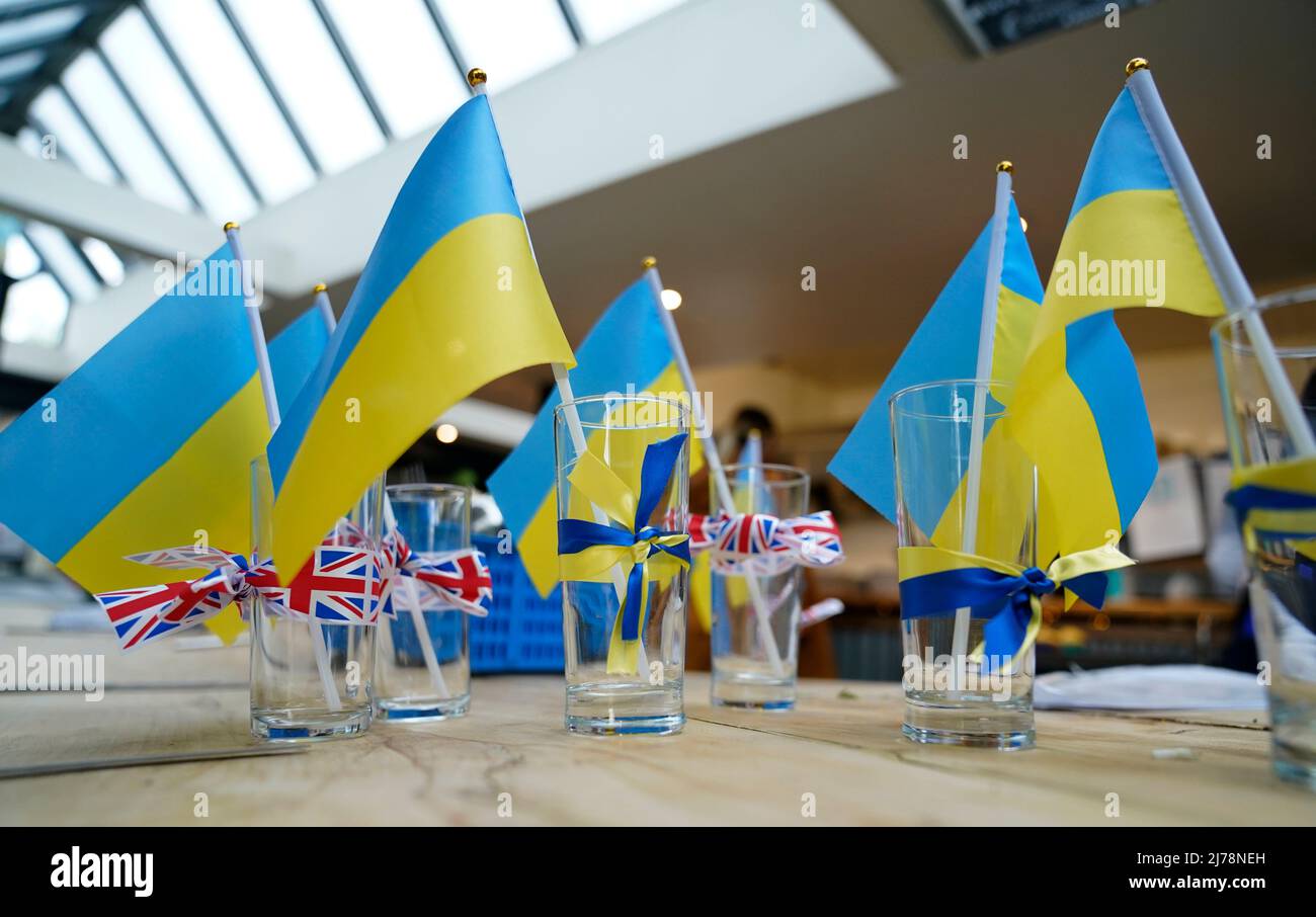 Table decorations with Union and Ukrainian flags on them are placed on ...