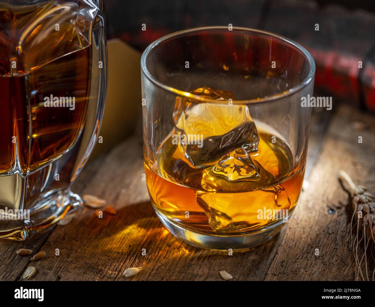 Carafe of whisky and glass of whisky on old wooden cask at the dark ...