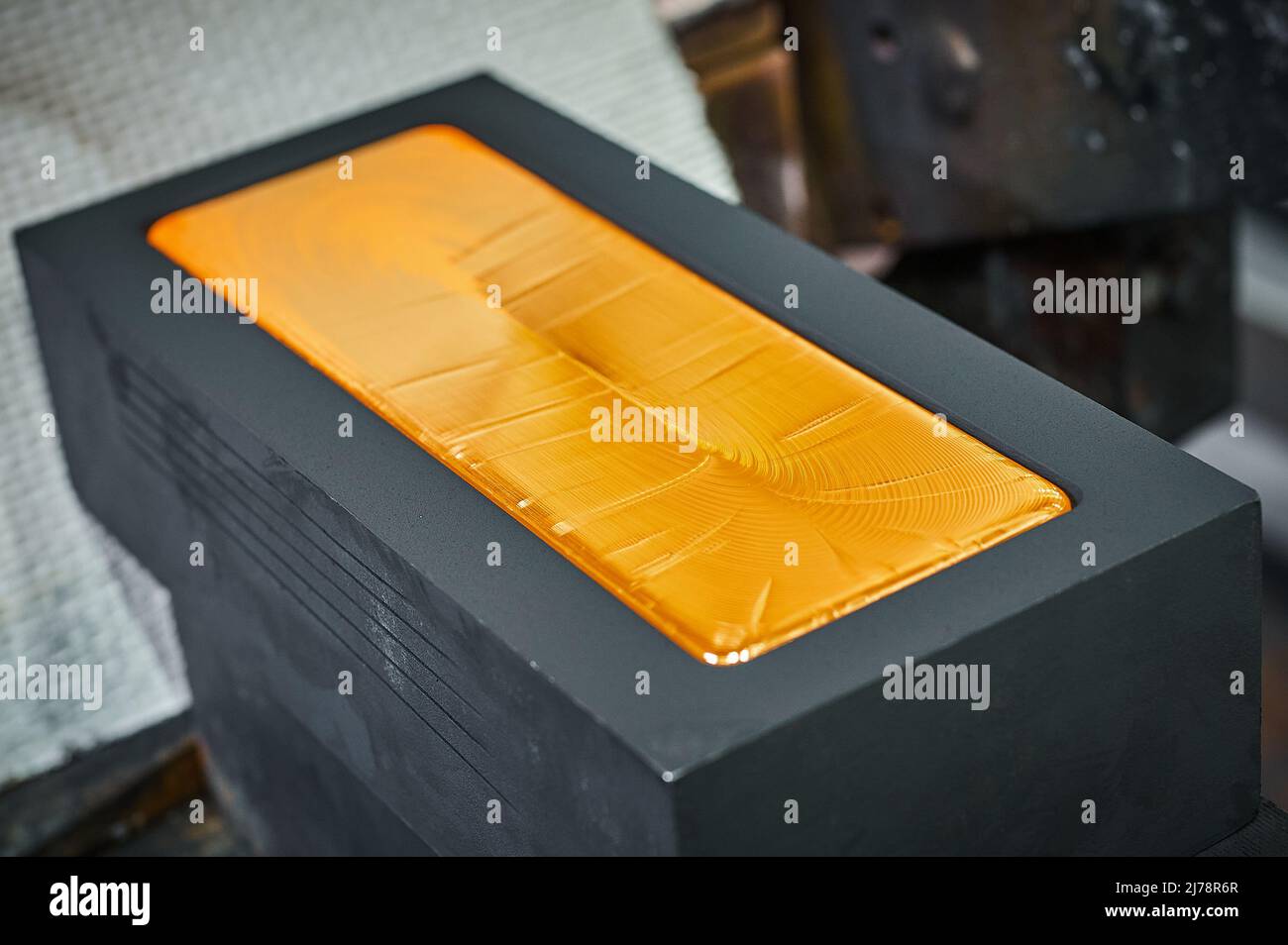 Gold ingot in graphite casting form on workbench at plant Stock Photo ...