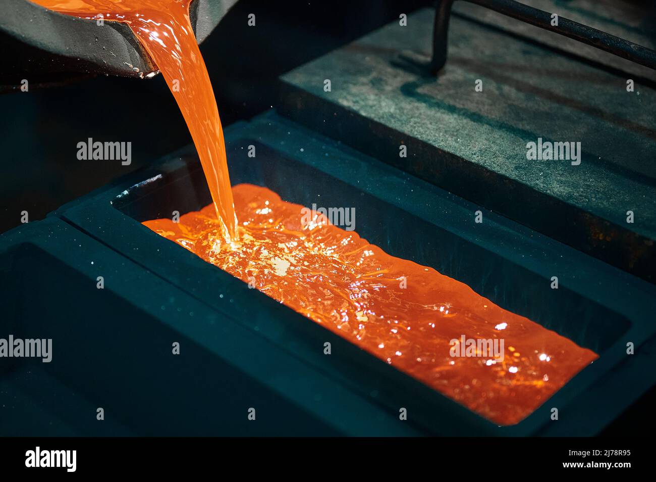 Pouring silver into graphite casting form in dark workshop Stock Photo ...