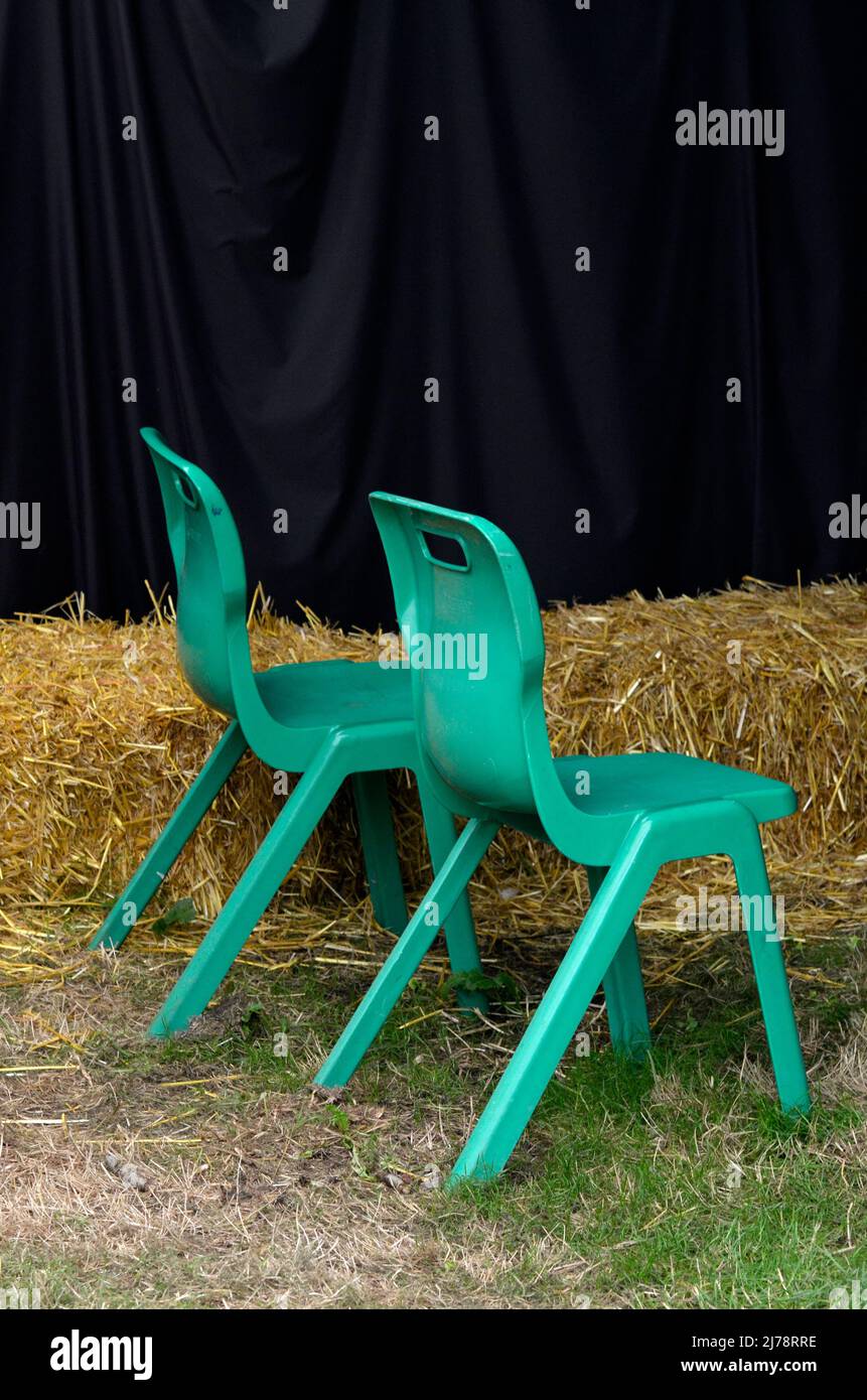 two green plastic garden chairsand straw bales Stock Photo - Alamy