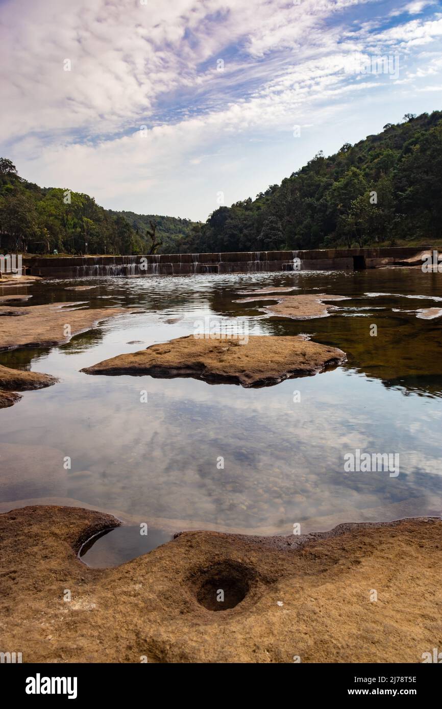 riverbed stone hole with water and surrounded by green forests from ...