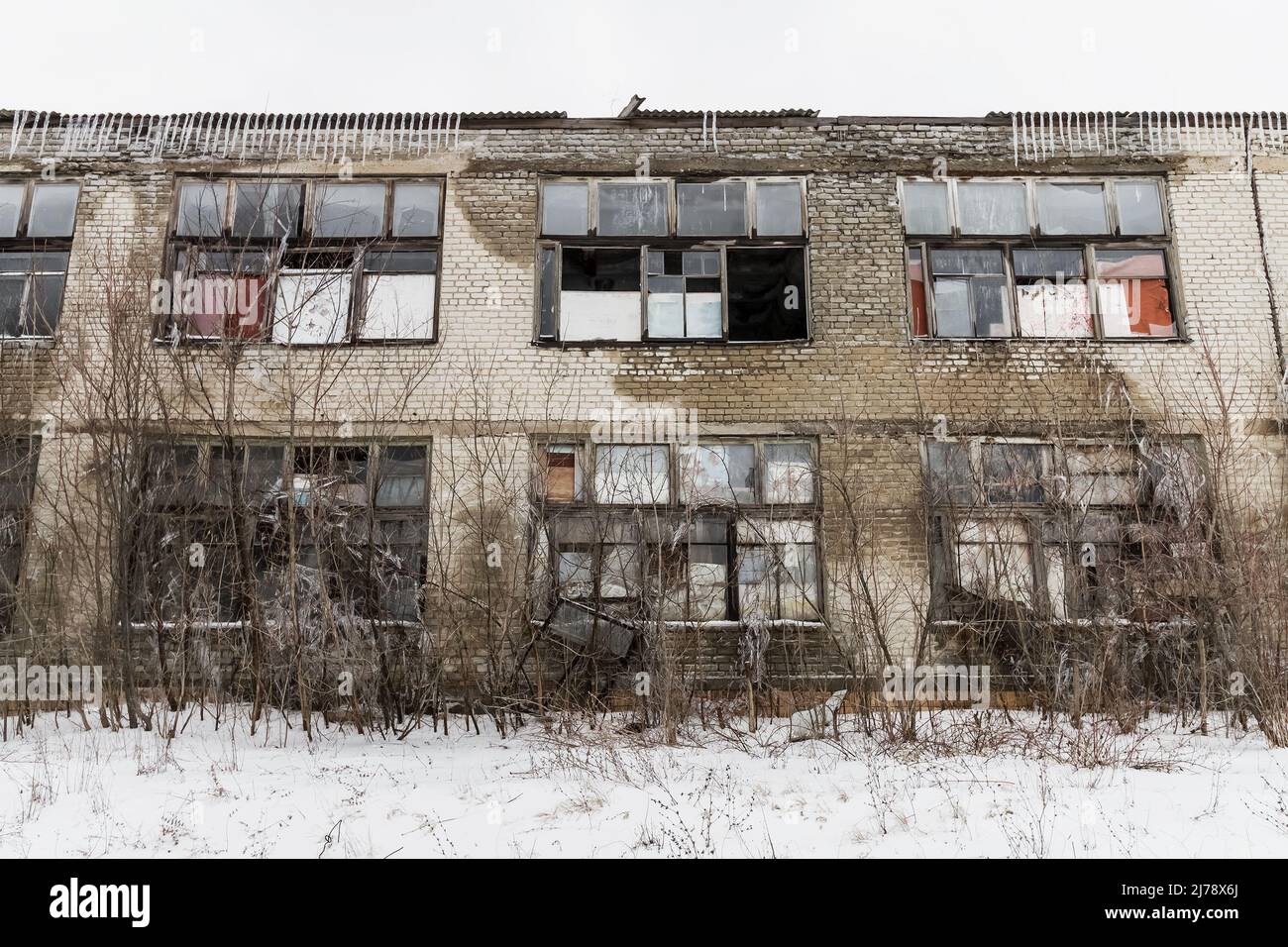View of an abandoned dilapidated brick building with big destroyed windows Stock Photo - Alamy