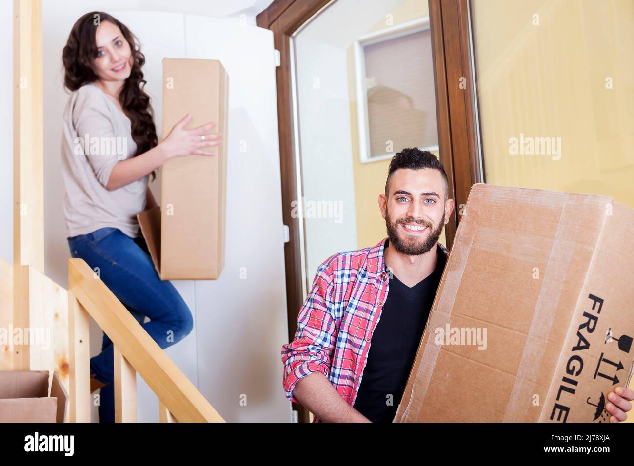 young couple carrying the boxes in new house Stock Photo - Alamy