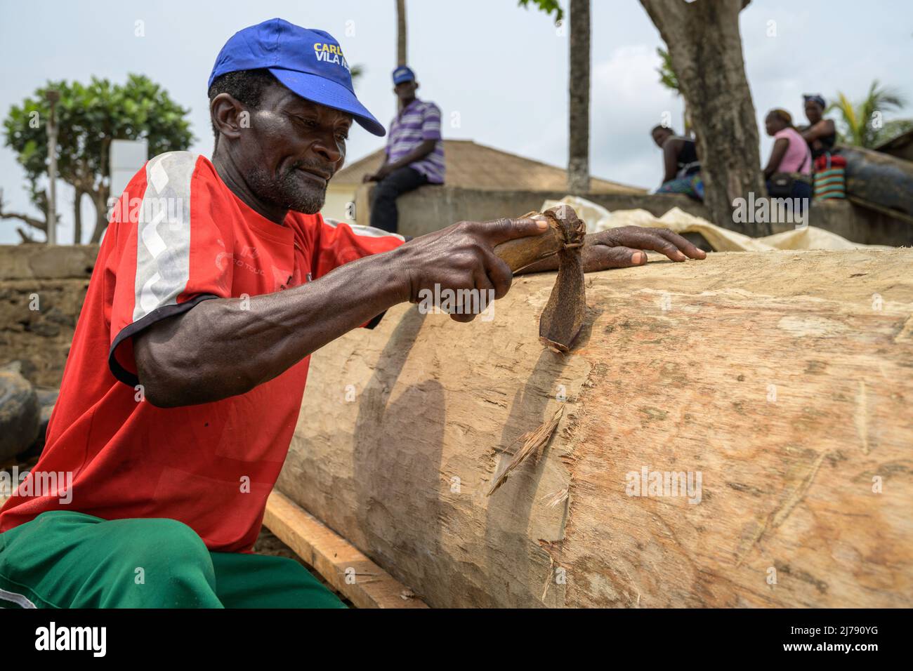 Man hand carving a large log to make a canoe Stock Photo - Alamy