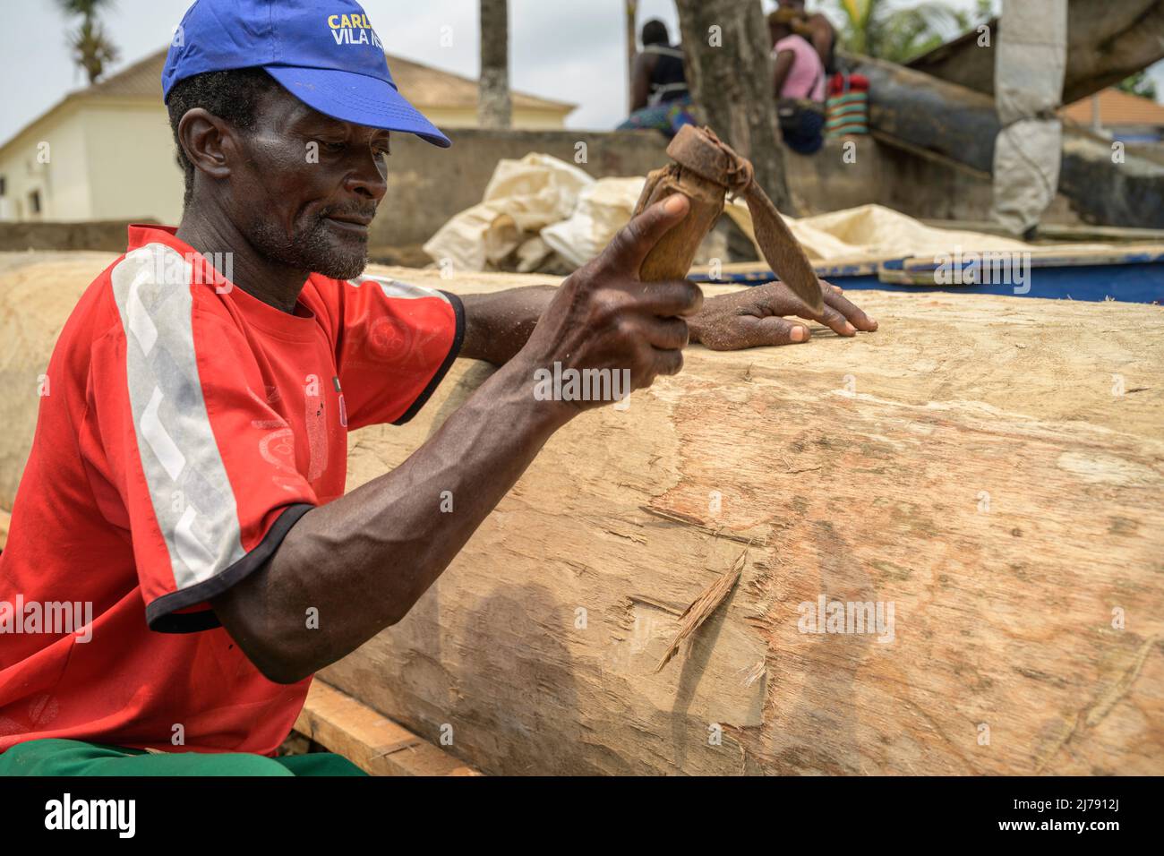 Man hand carving a large log to make a canoe Stock Photo - Alamy