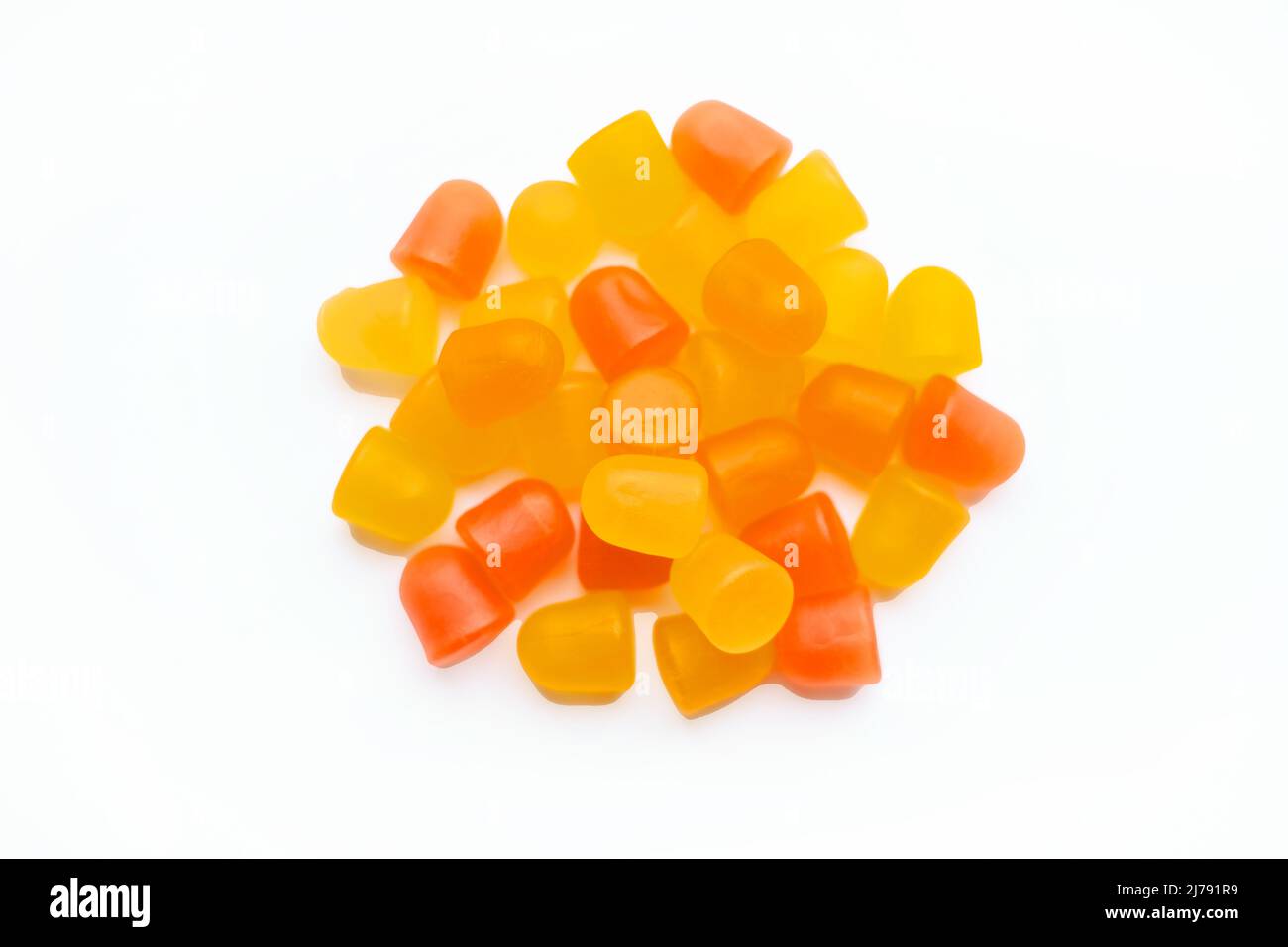 Close-up texture of orange and yellow multivitamin gummies in the form ...