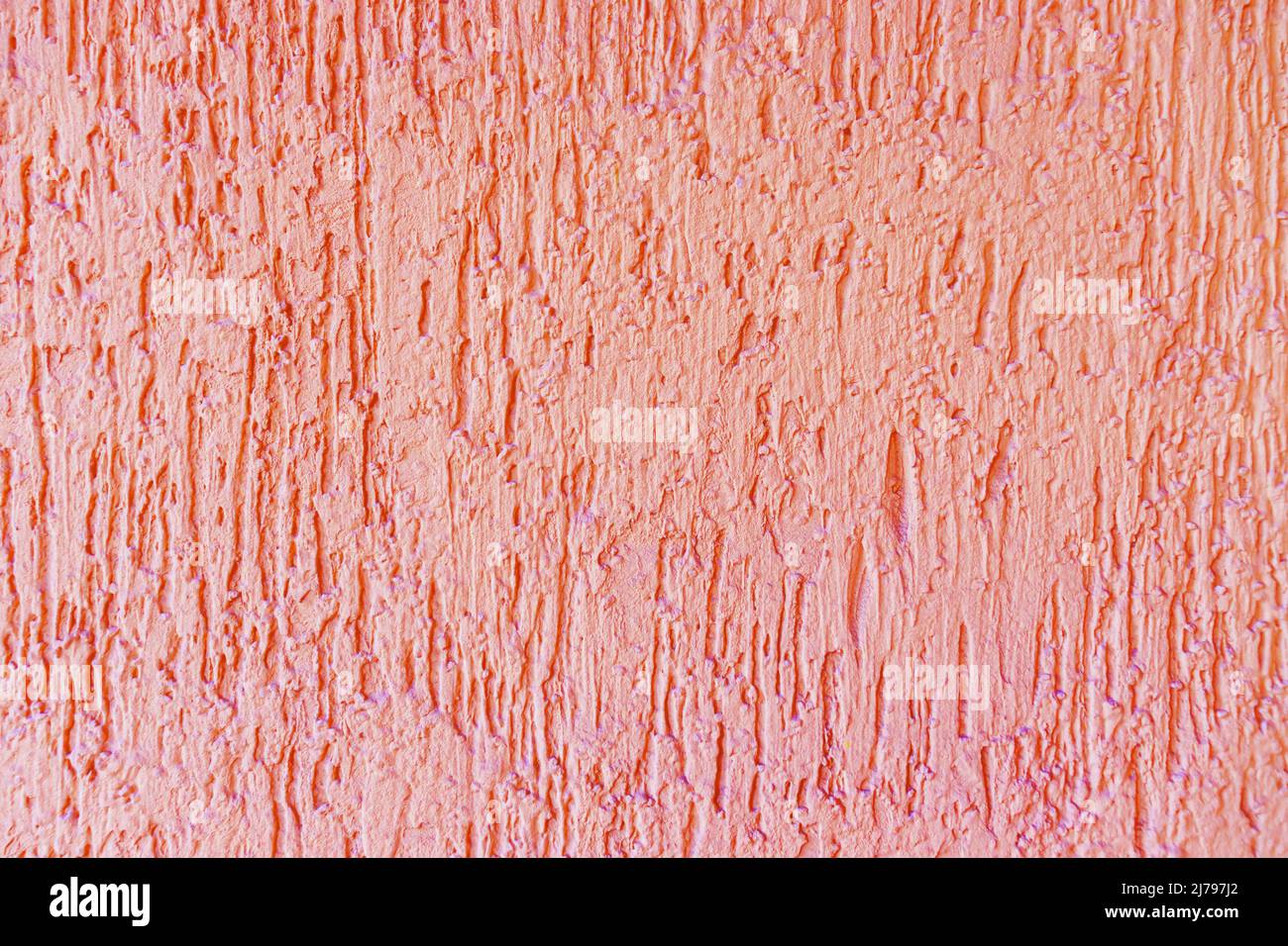 The pink plaster texture of the exterior wall of the building is close ...